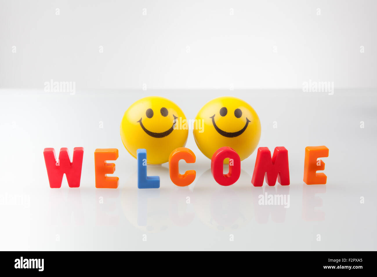 Welcome sign with two smileys on white background Stock Photo - Alamy