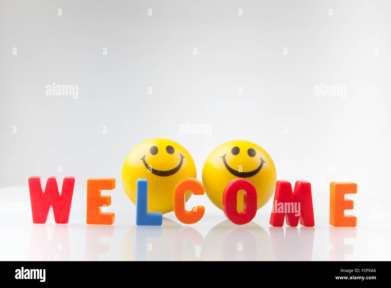 Welcome sign with two smileys on white background Stock Photo - Alamy