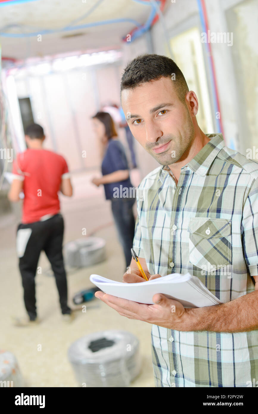 Builder taking notes as he works Stock Photo - Alamy