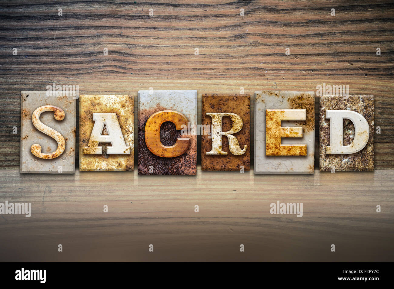 The word "SACRED" written in rusty metal letterpress type sitting on a ...
