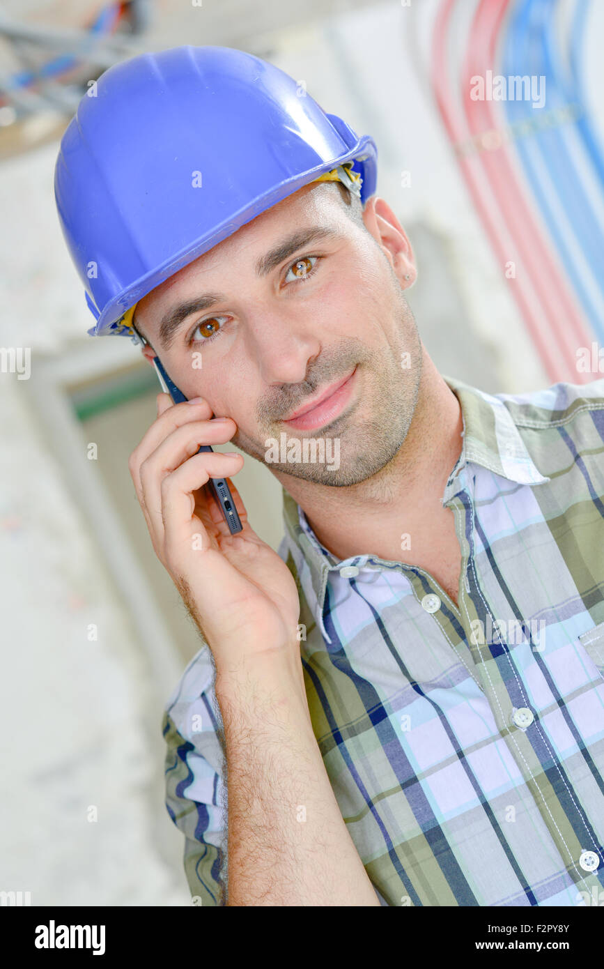 Smiling construction worker on telephone Stock Photo - Alamy