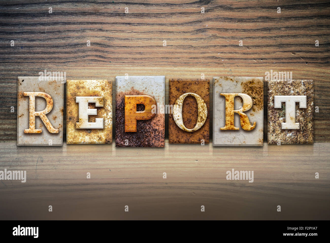 The word "REPORT" written in rusty metal letterpress type sitting on a ...
