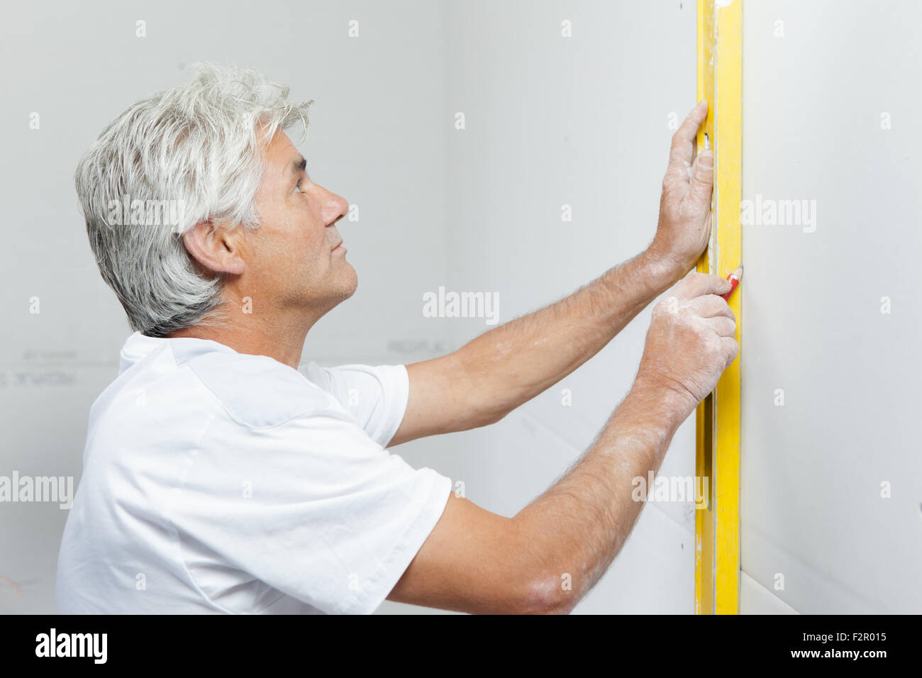 Checking wall with a spirit level Stock Photo - Alamy