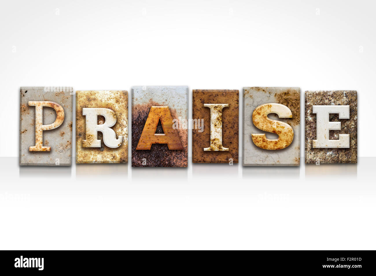 The word "PRAISE" written in rusty metal letterpress type isolated on a ...