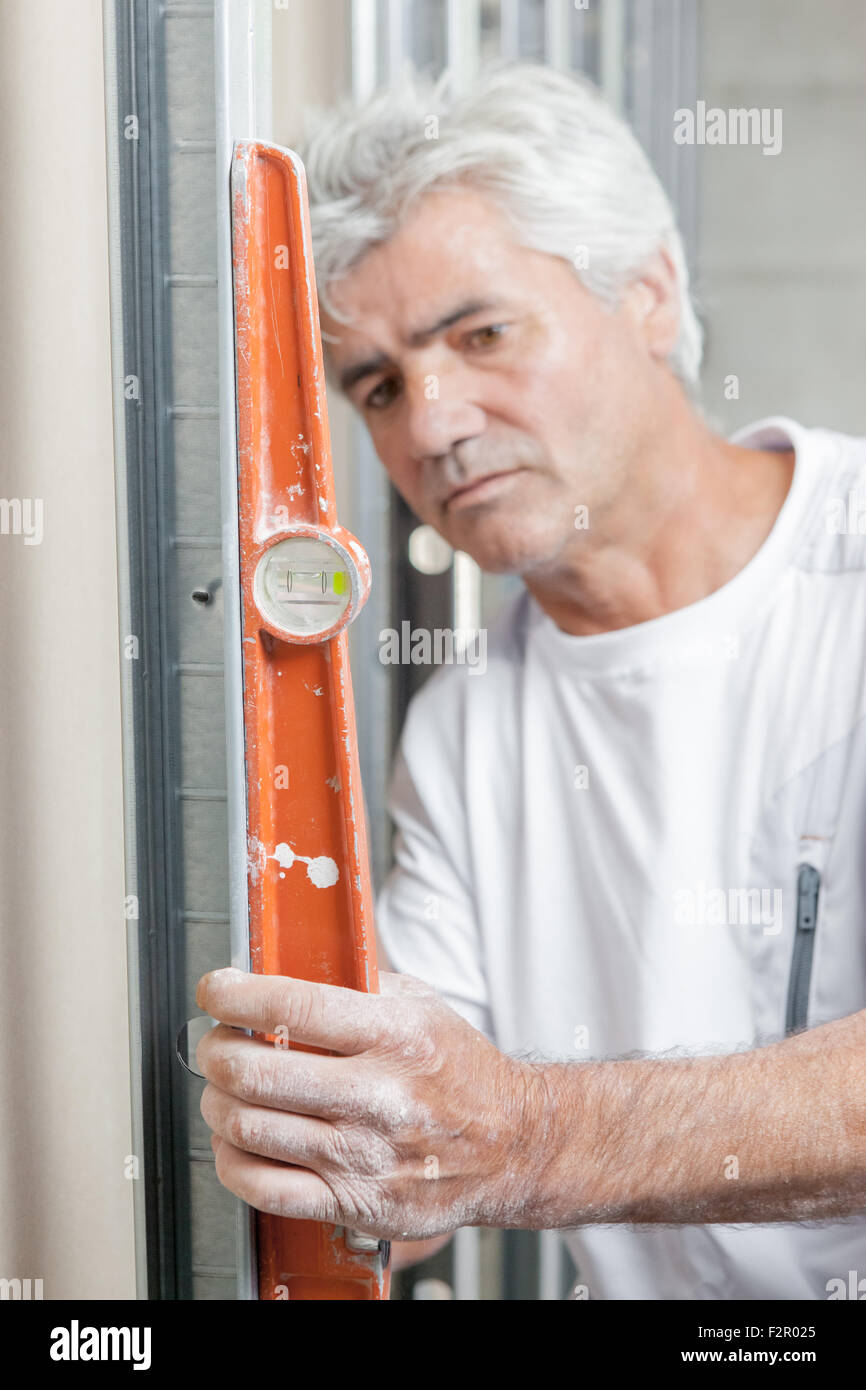 Mason using an orange spirit level Stock Photo - Alamy
