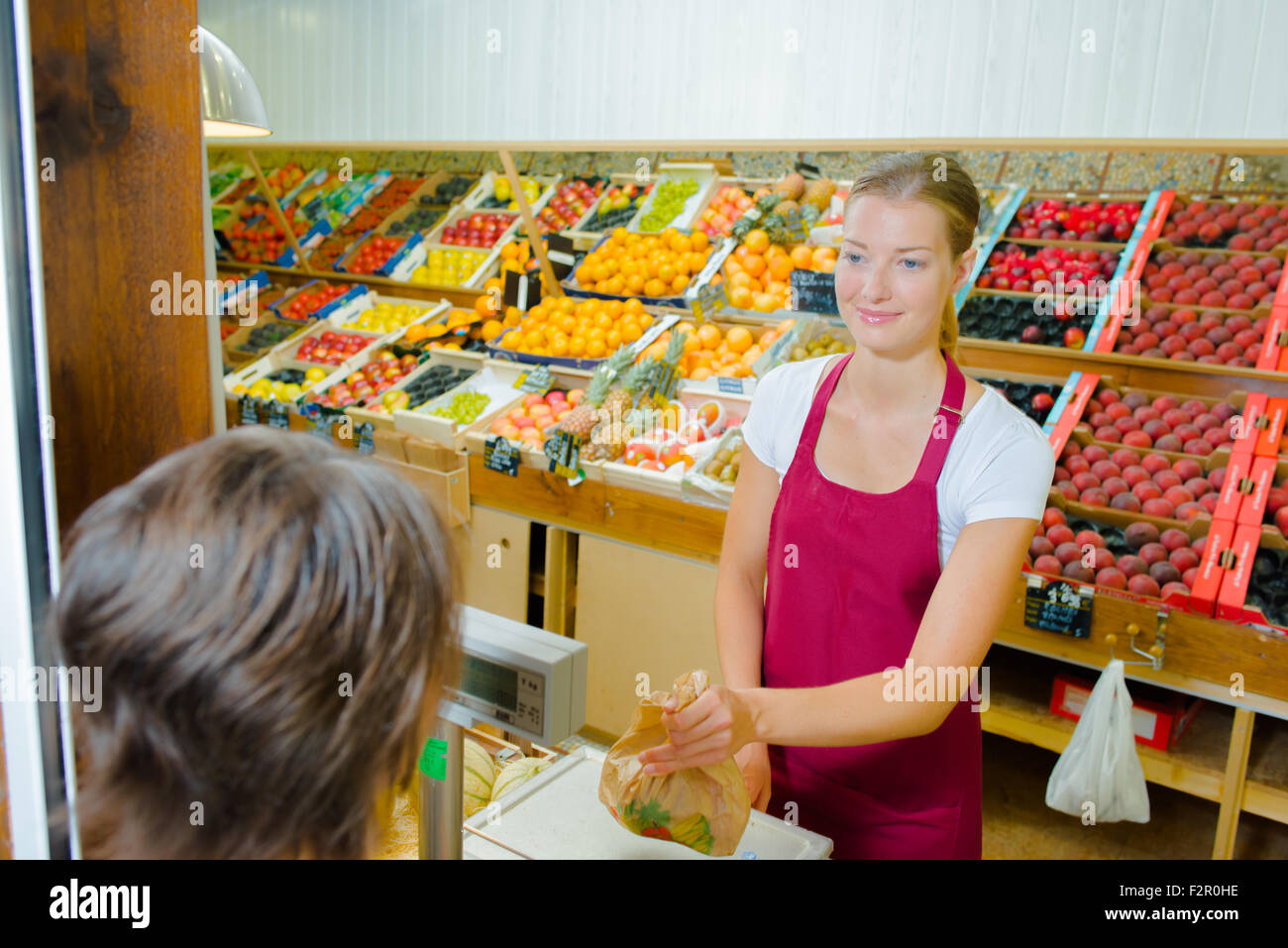 Shop worker weighing fruit Stock Photo - Alamy