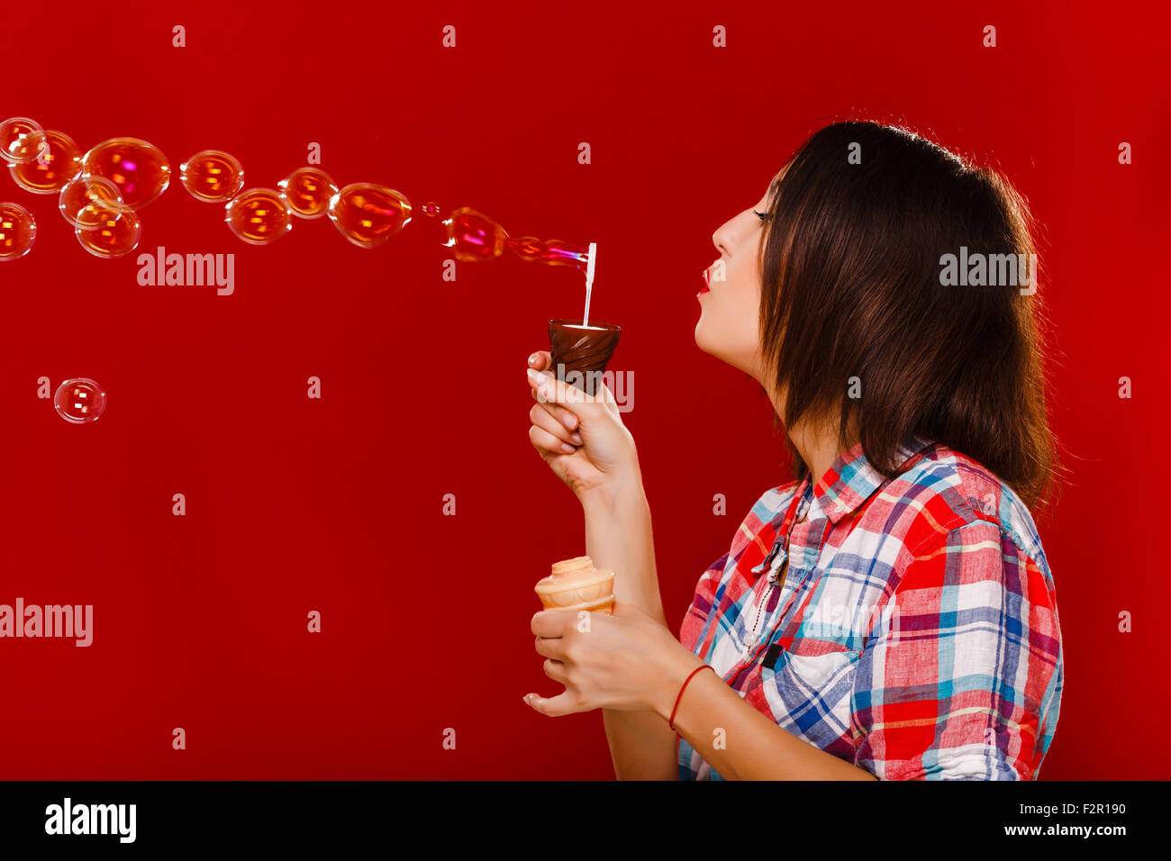 Young brunette girl, with short haircut, wearing in red checkered shirt ...