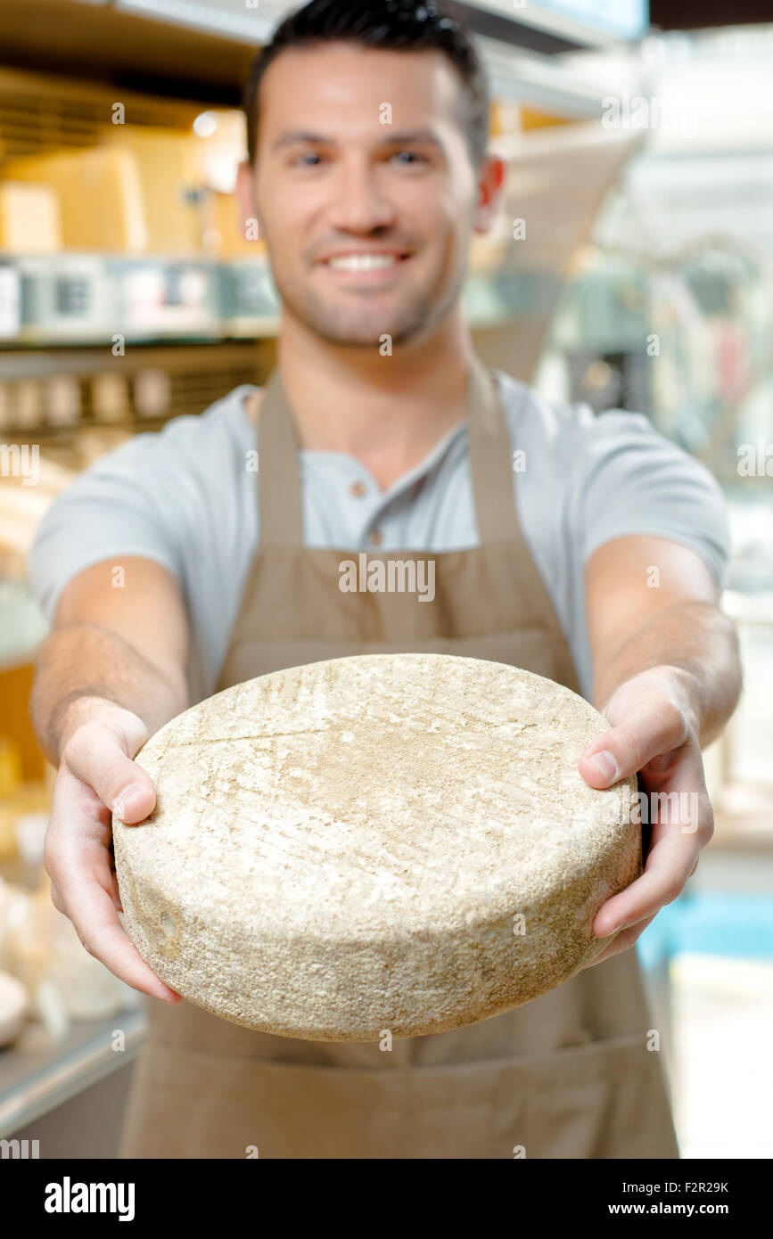 Man holding a wheel of cheese Stock Photo - Alamy