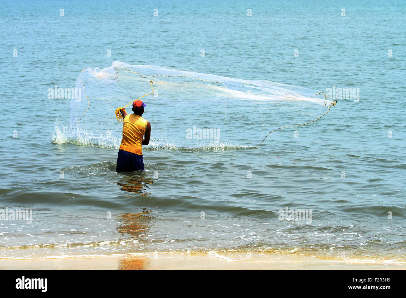 fisherman throwing fish net Stock Photo - Alamy
