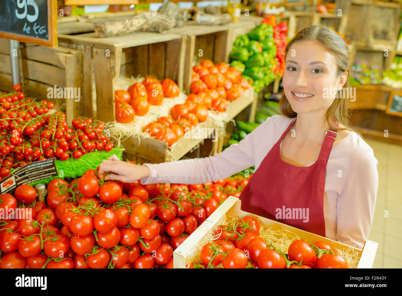 Supermarket worker by the vegetables Stock Photo - Alamy