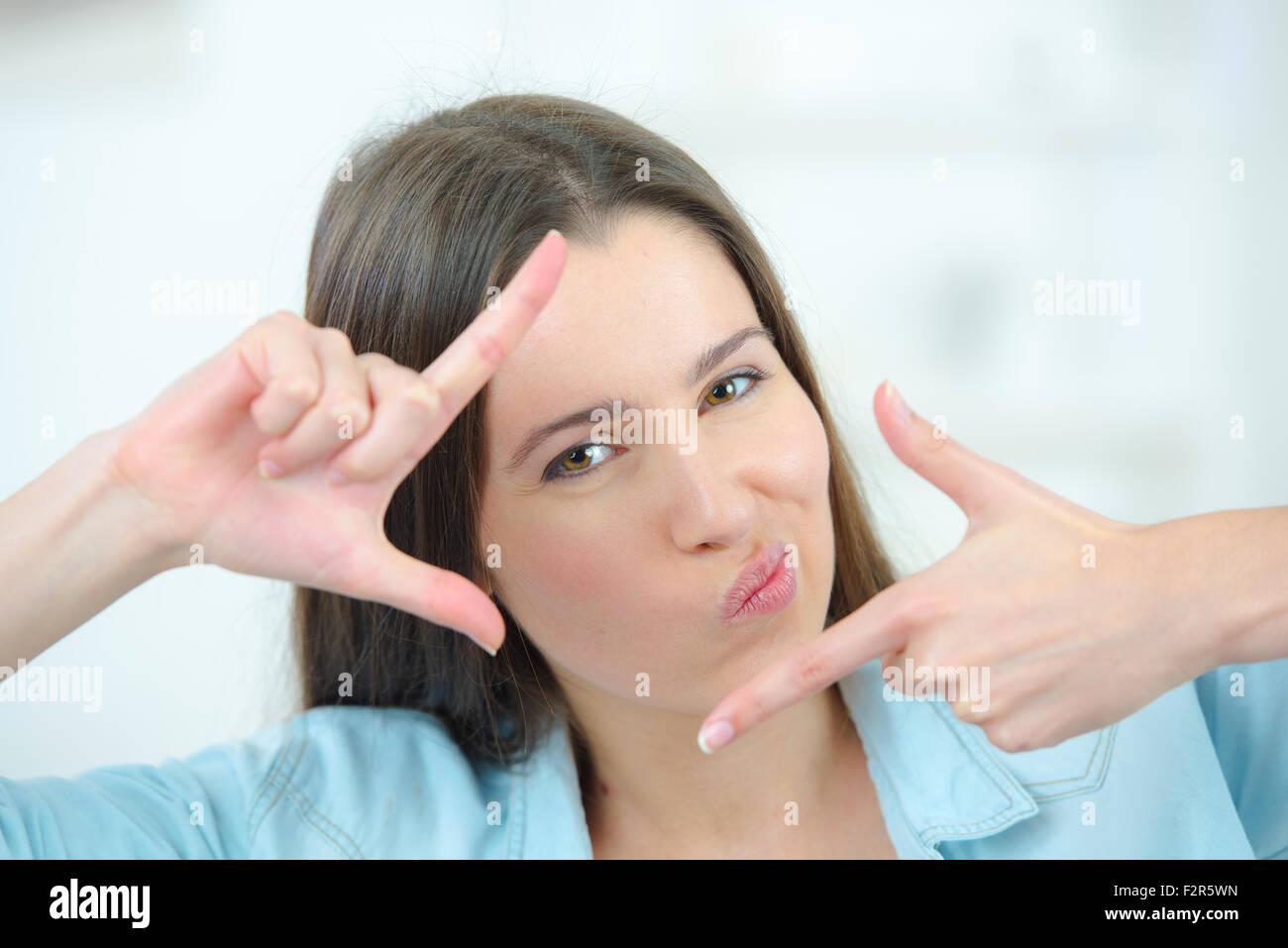 Framing her face with her hands Stock Photo - Alamy