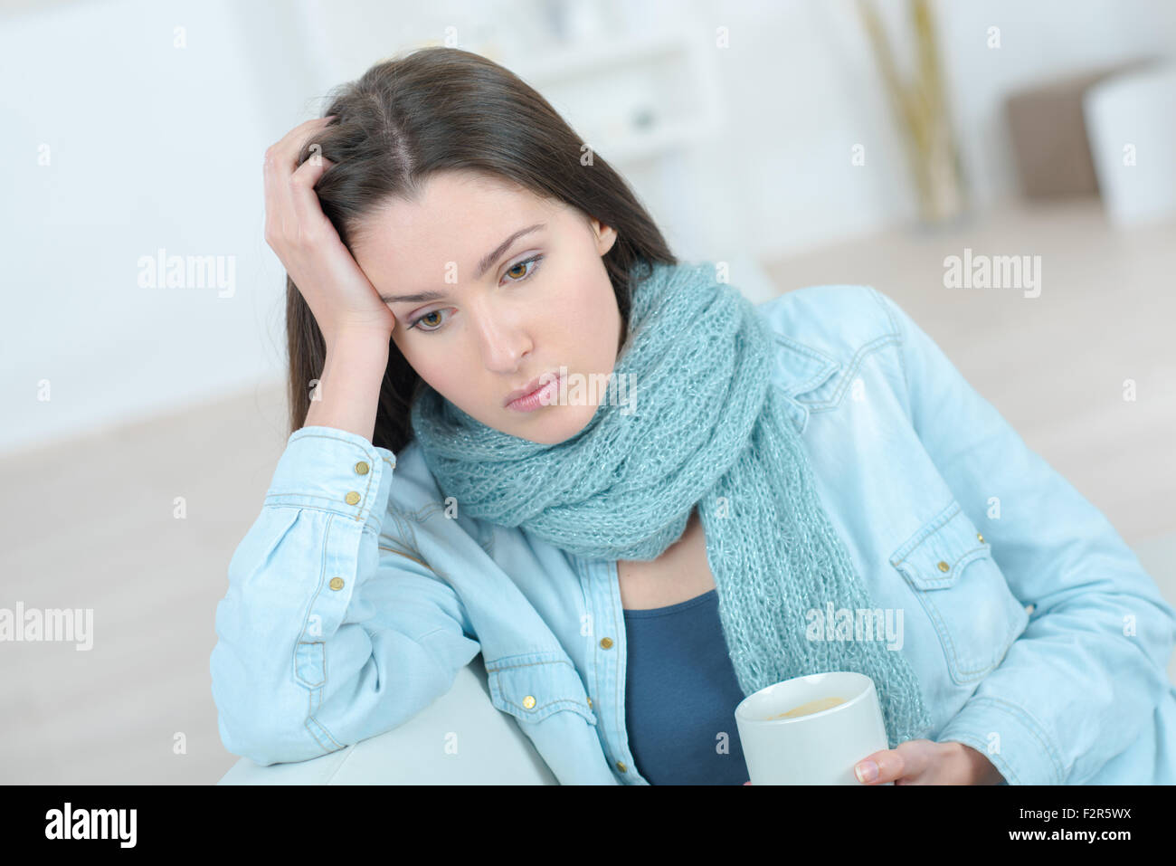 Sad woman holding a mug of coffee Stock Photo - Alamy