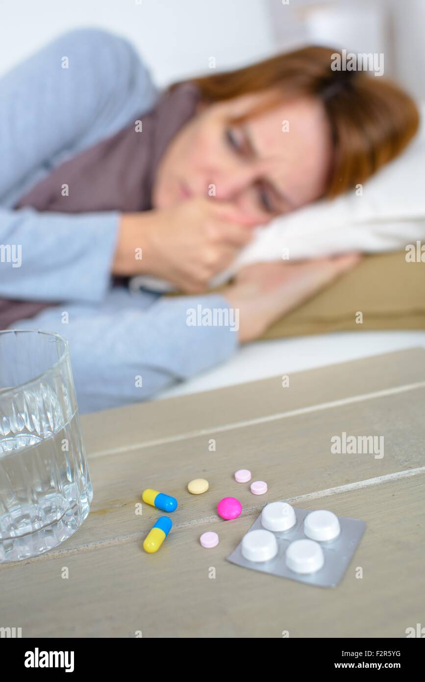 Sick woman laying on a sofa Stock Photo - Alamy