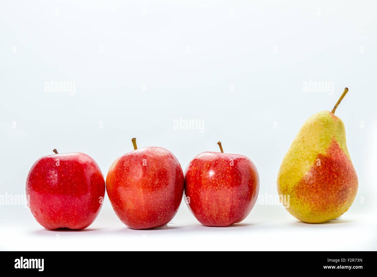 Three Apple one pear isolated on white background Stock Photo - Alamy