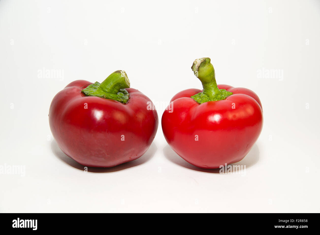 Two red peppers on a white background Stock Photo - Alamy