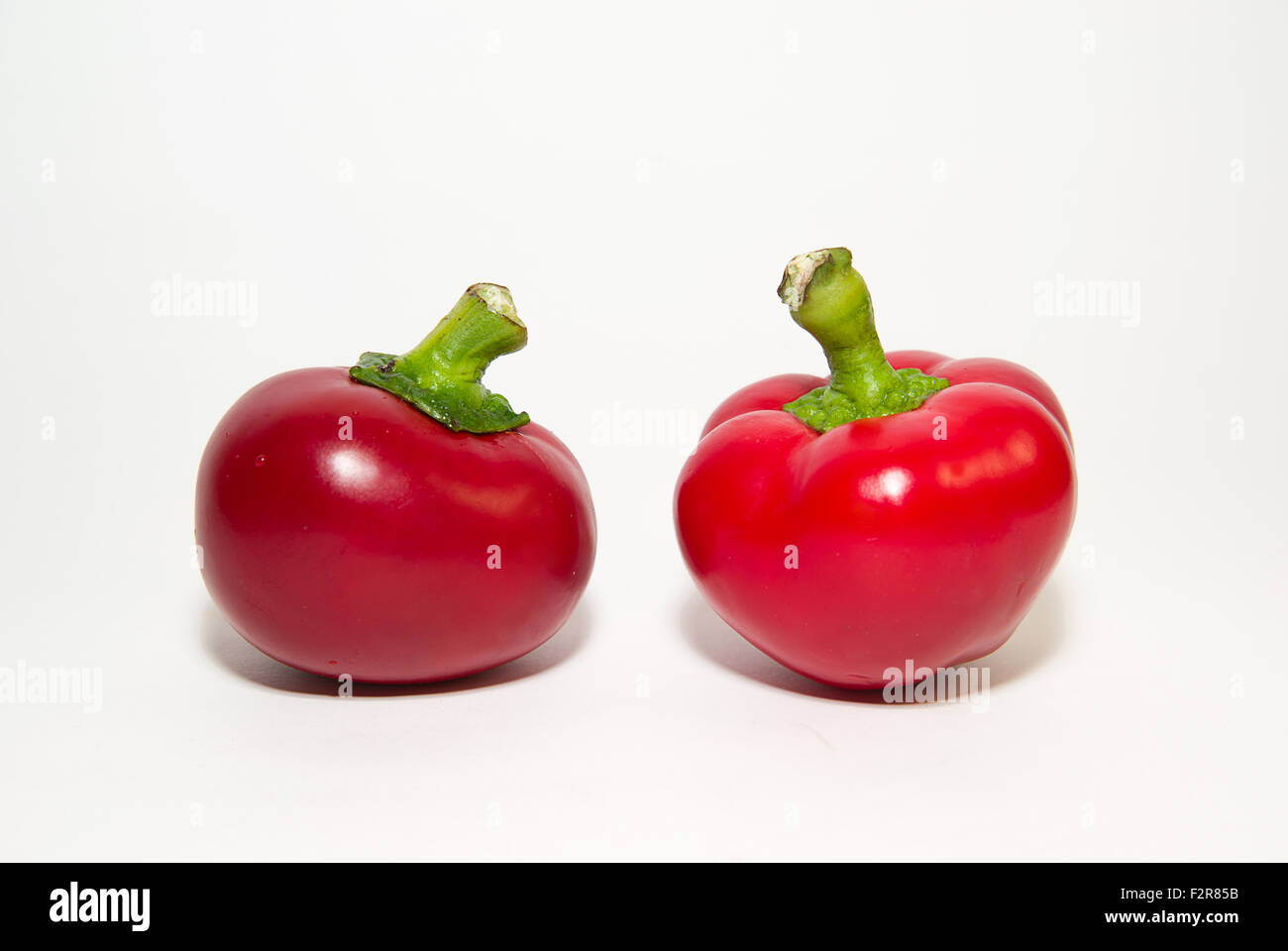 Two red peppers on a white background Stock Photo - Alamy