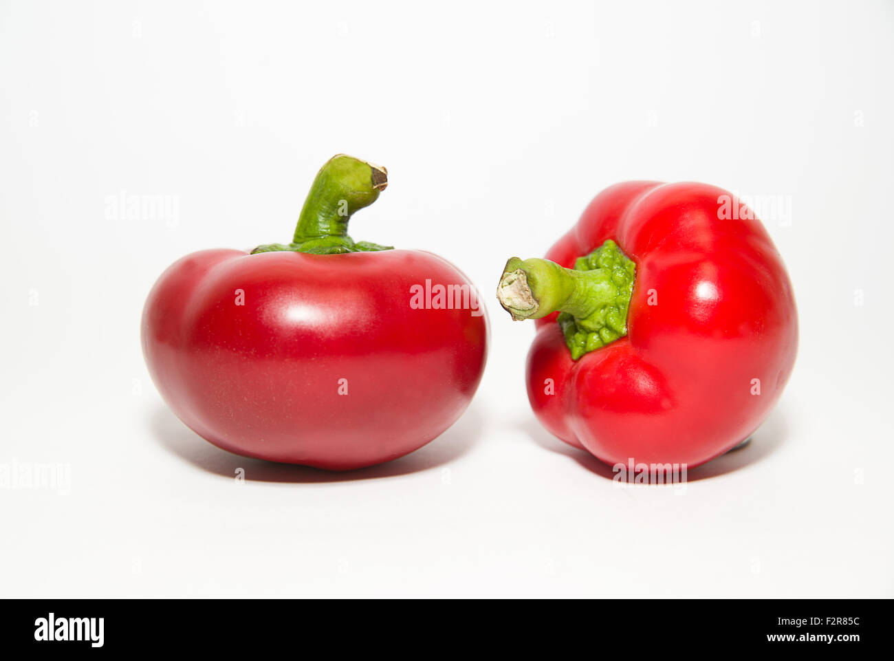 Two red peppers on a white background Stock Photo - Alamy