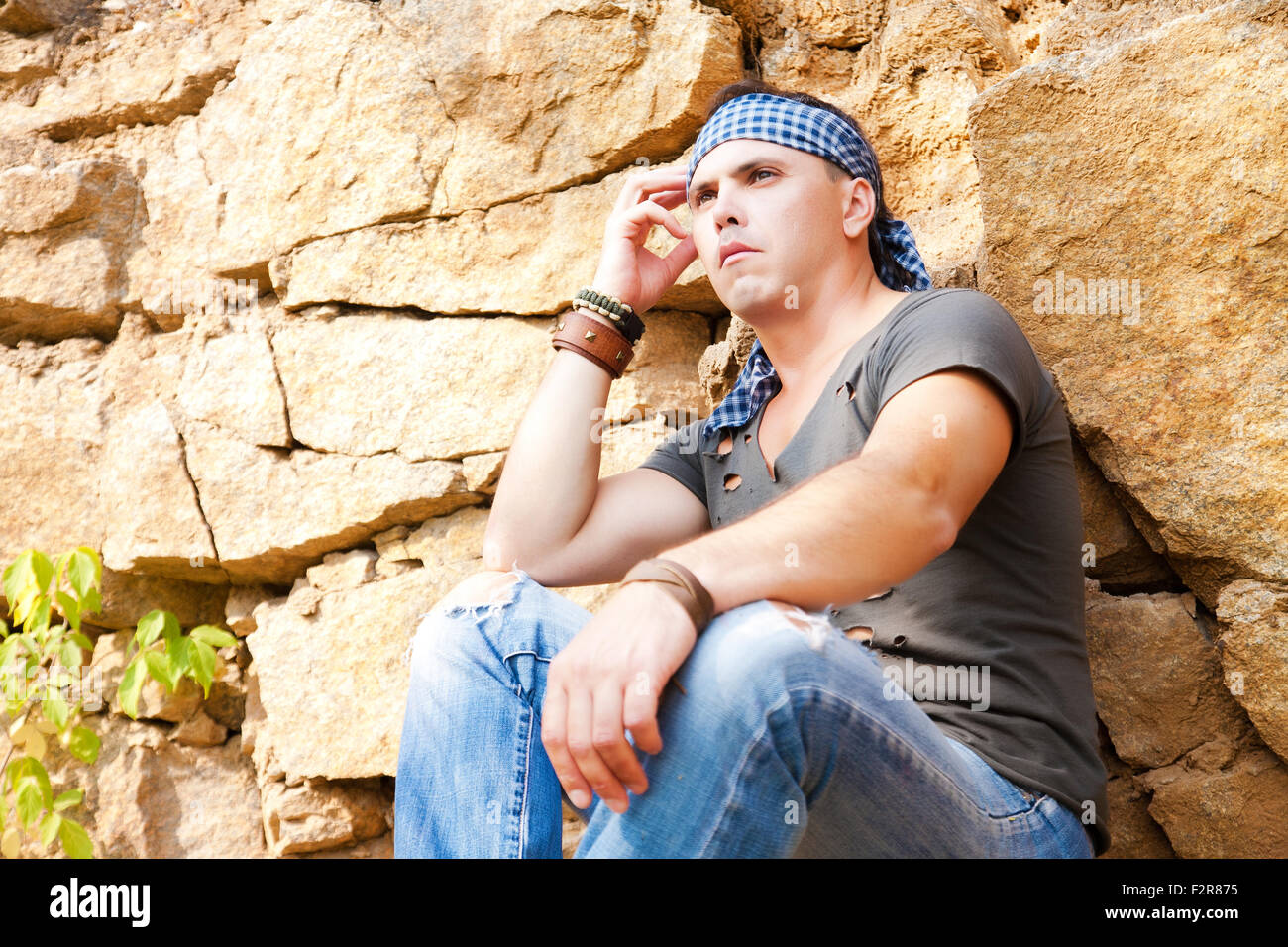 Man resting in the mountains sitting on the rock Stock Photo - Alamy