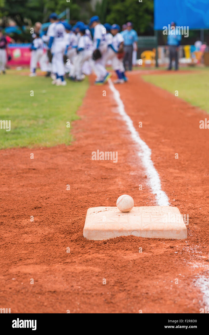 baseball and base on baseball field with players and judges on ...