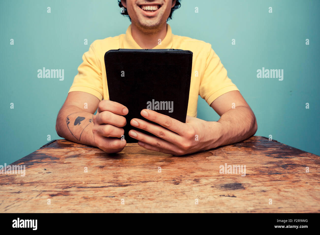 Young man using tablet at table Stock Photo - Alamy