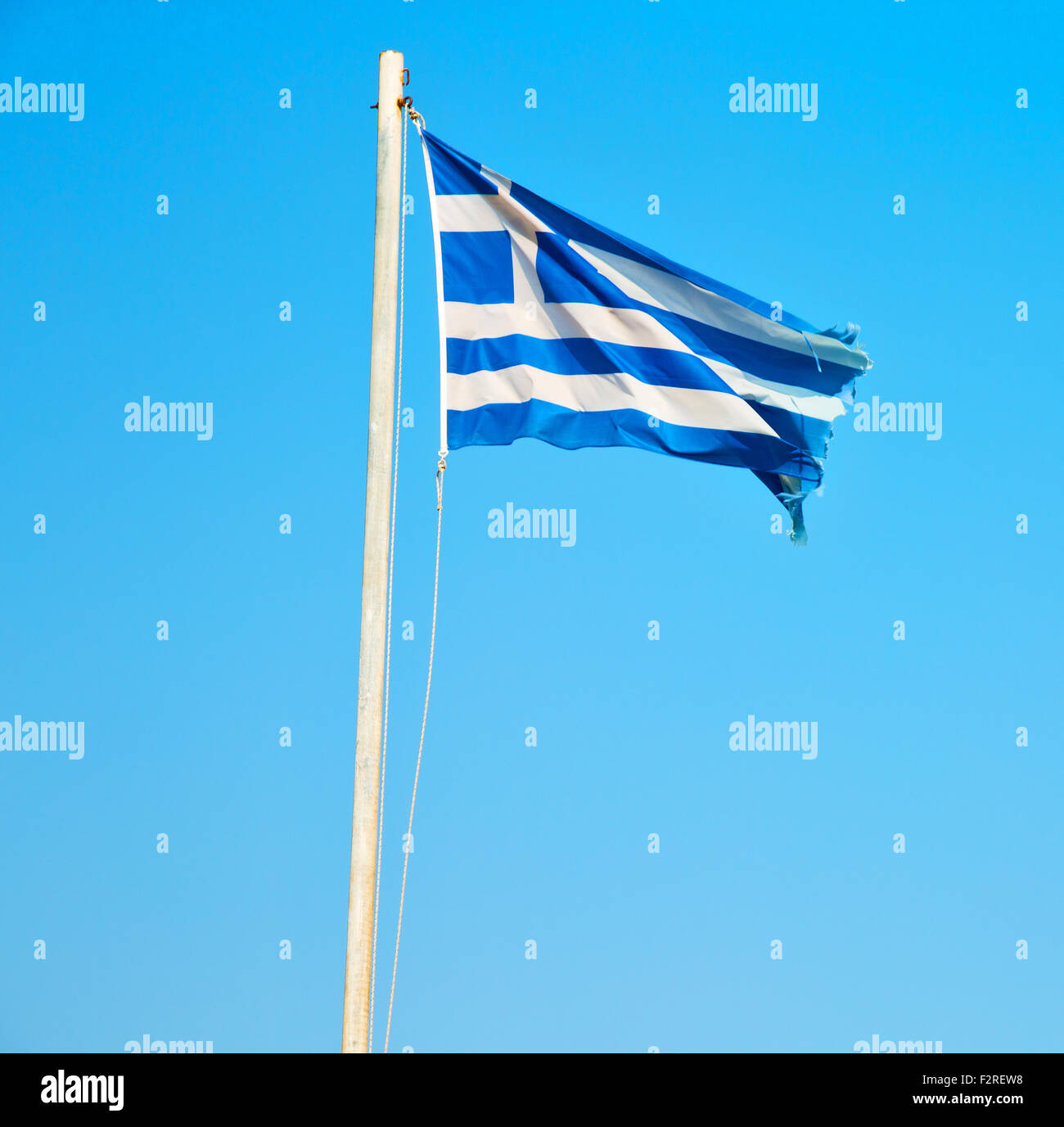 waving greece flag in the blue sky and flagpole Stock Photo - Alamy