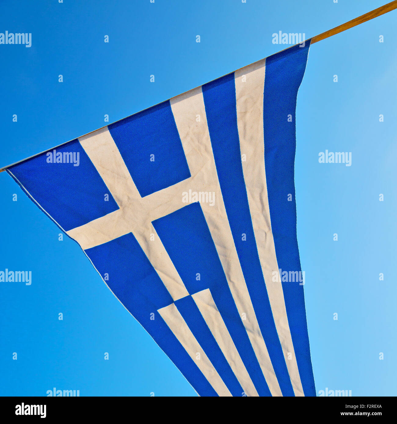 waving greece flag in the blue sky and flagpole Stock Photo - Alamy
