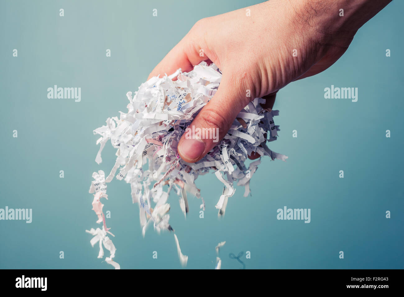 Hand is holding a bunch of shredded paper Stock Photo - Alamy
