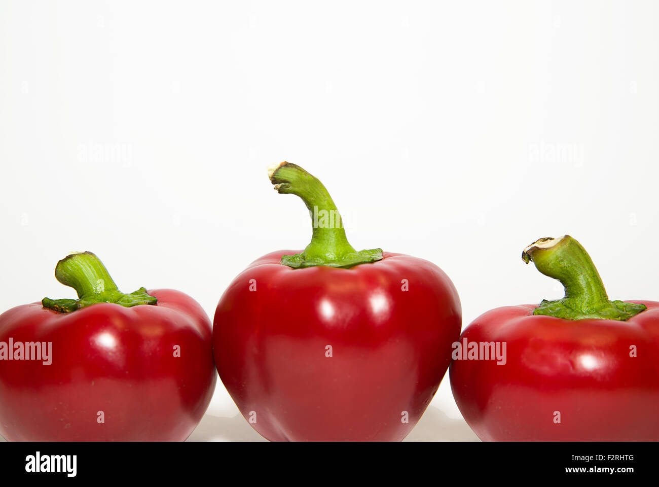 Three red peppers on a white background Stock Photo - Alamy