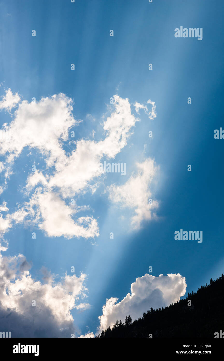 Blue sky with clouds and rays of light Stock Photo - Alamy