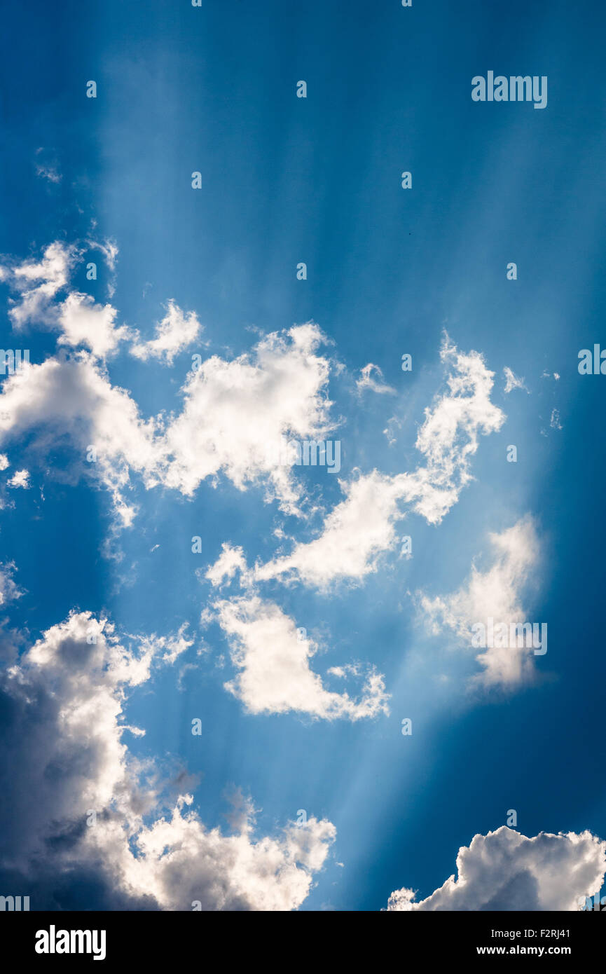 Blue sky with clouds and rays of light Stock Photo - Alamy