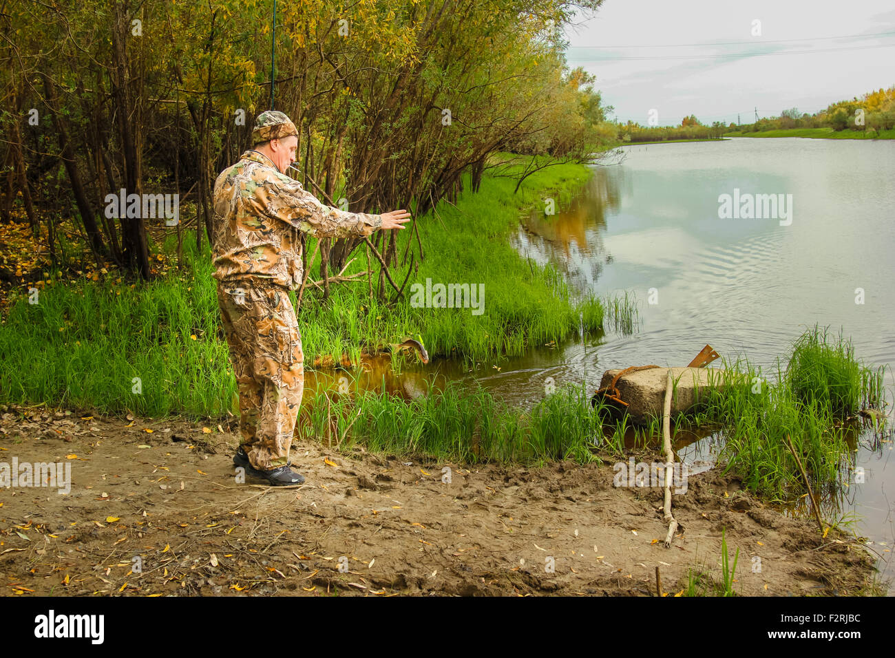 A fisherman on the river catching pike on spinning Stock Photo - Alamy