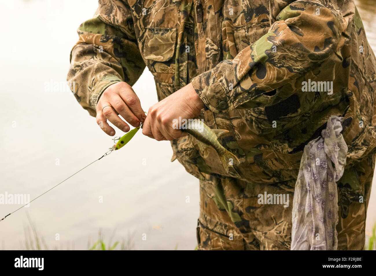 A fisherman on the river catching pike on spinning Stock Photo - Alamy