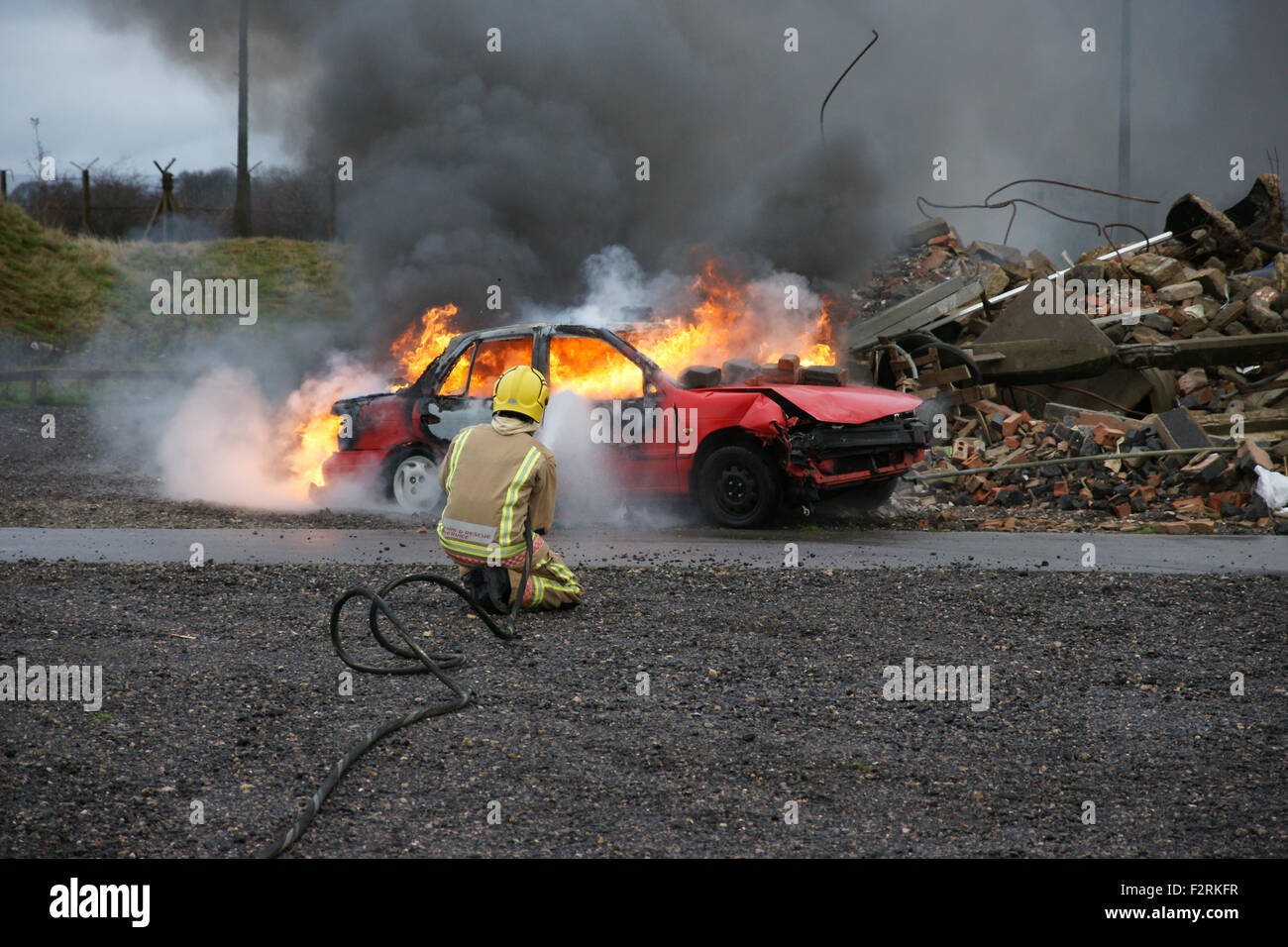 car on fire, fire fighter fighting car fire incident Stock Photo - Alamy