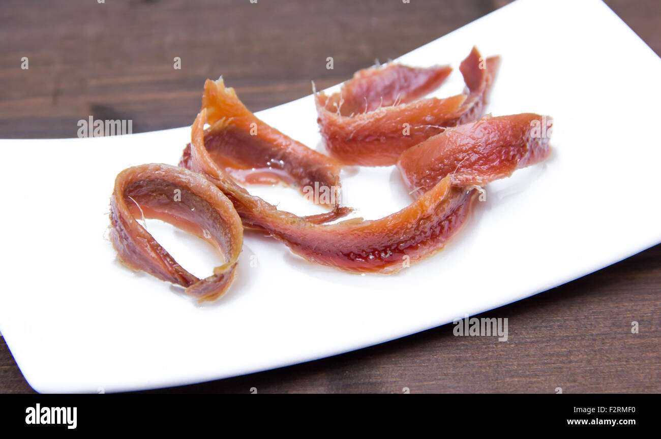 Anchovy fillets on tray on wooden table Stock Photo - Alamy