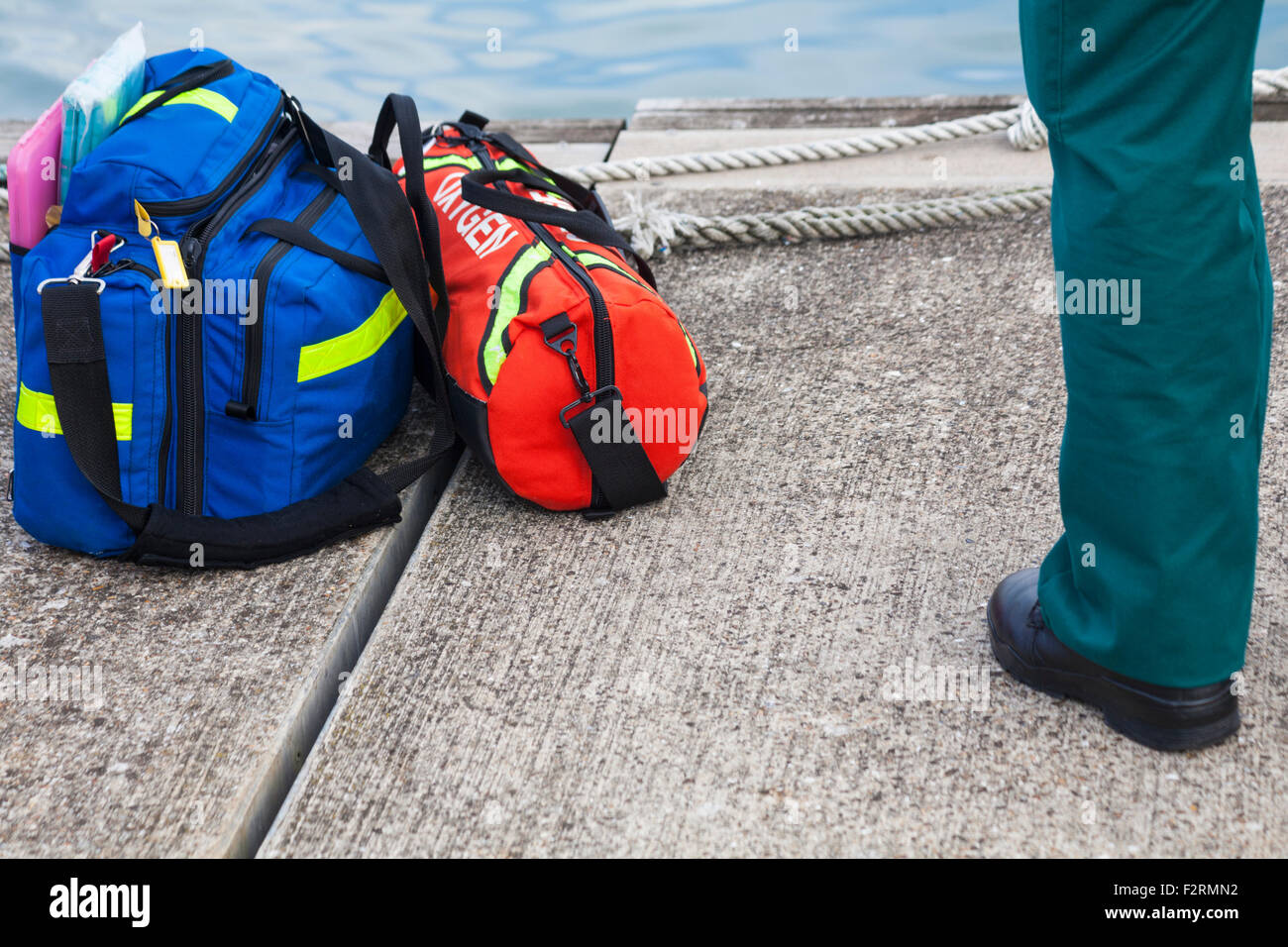 Ambulance man standing on quayside with oxygen and emergency kit at ...