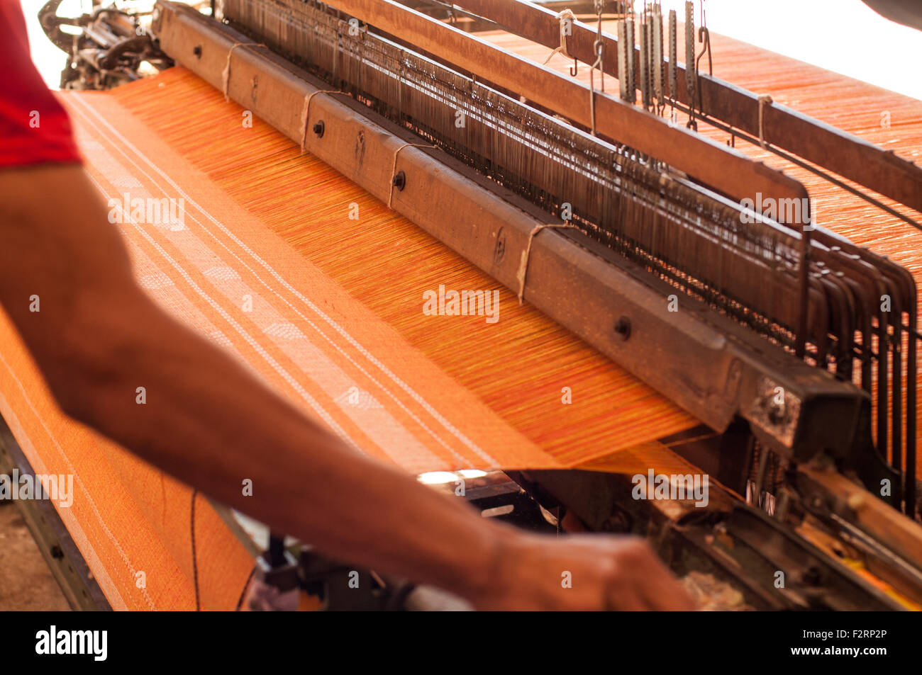 A loom making orange summer blankets Stock Photo - Alamy