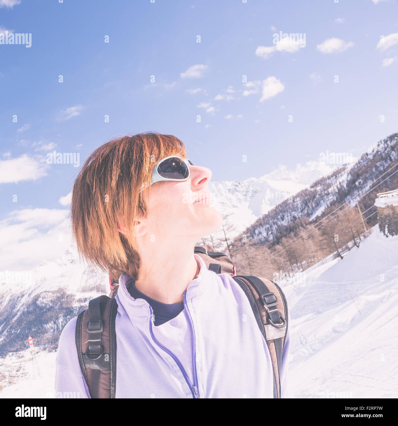 Adult female skier with backpack and sunglasses showing happiness on a ...