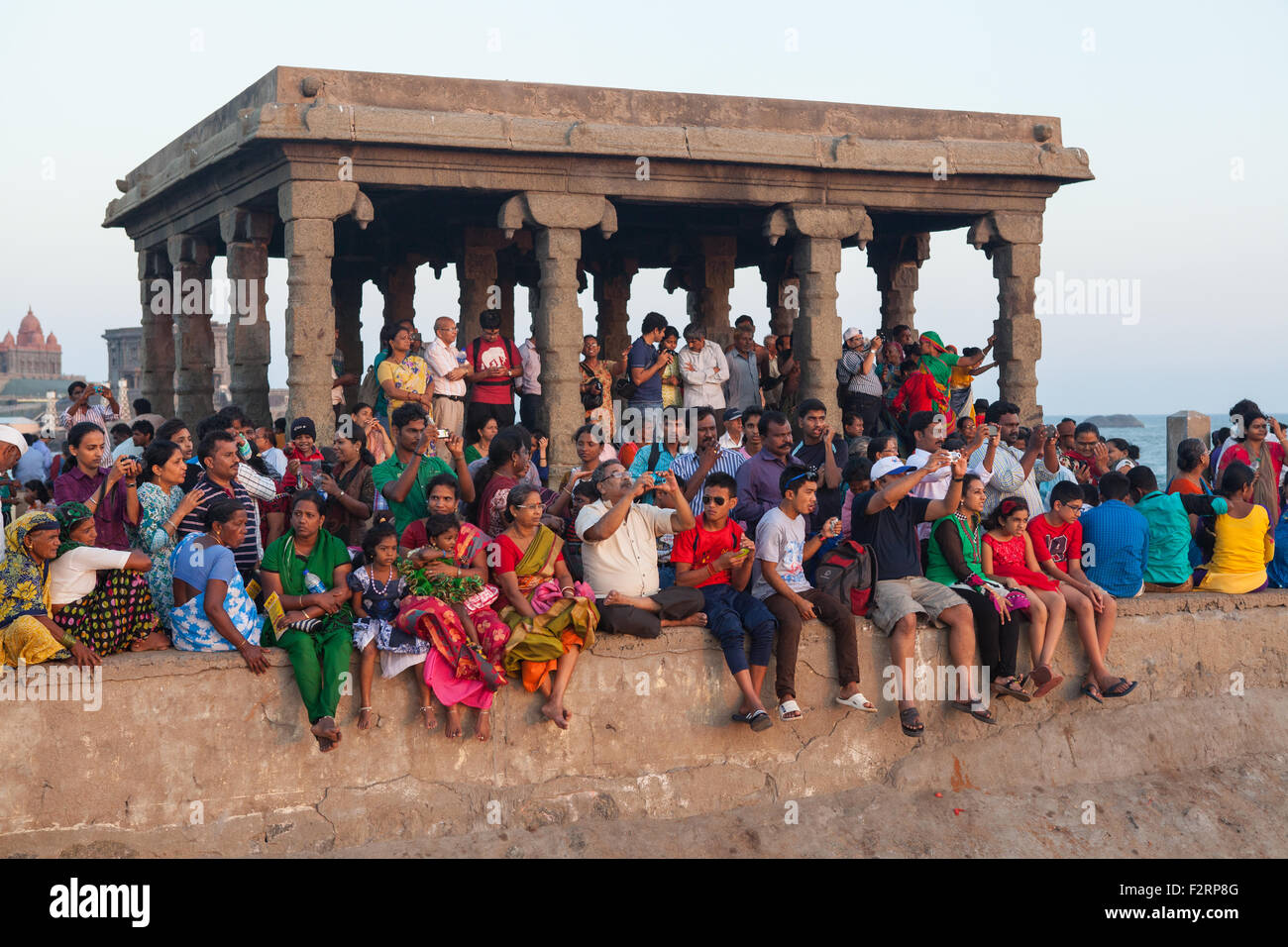 Pilgrims and devotees watch and take photographs from a temple as the ...