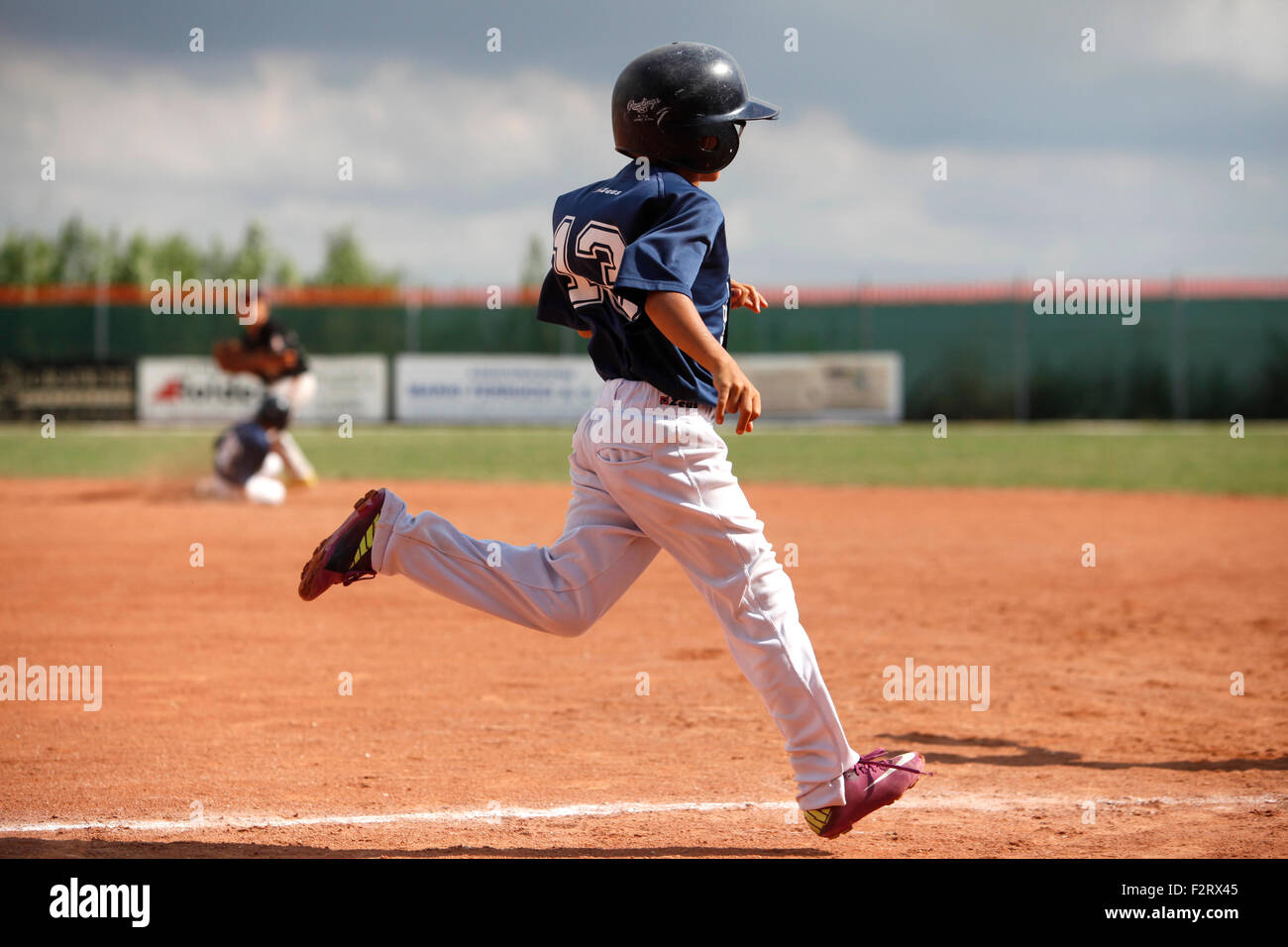 young boy running to base on baseball field Stock Photo - Alamy