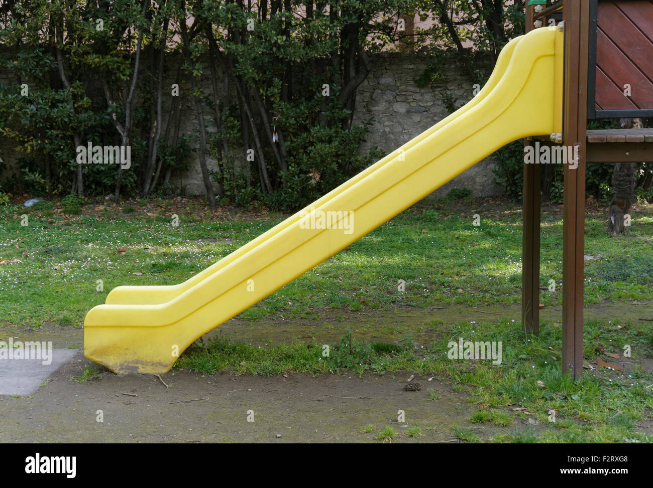 yellow plastic slide in playground Stock Photo - Alamy