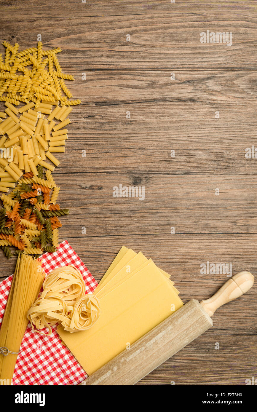 Uncooked italian pasta, brown wood table background Stock Photo - Alamy