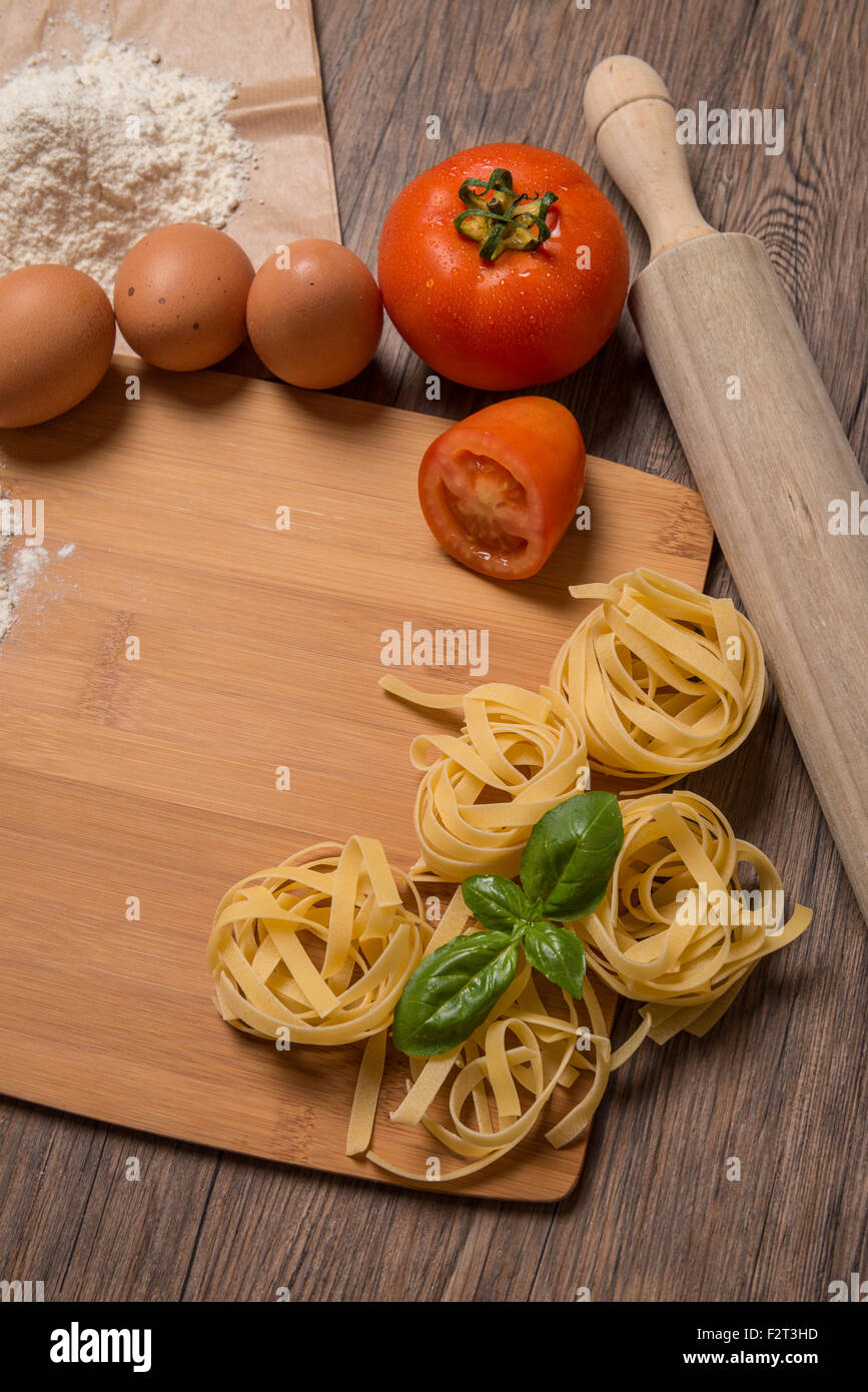 Uncooked italian pasta, brown wood table background Stock Photo - Alamy