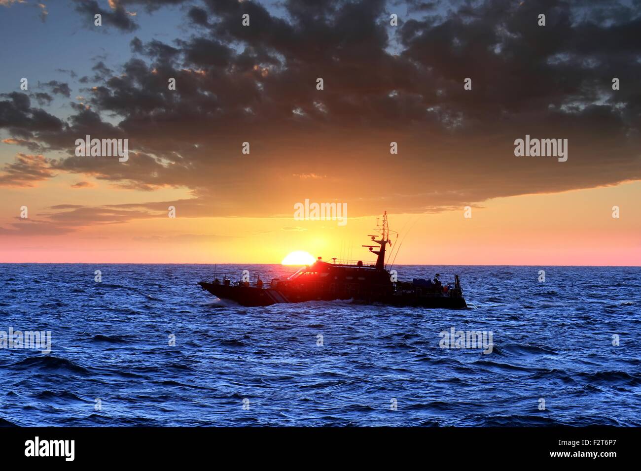 Coastguard sailing during the sunset Stock Photo - Alamy