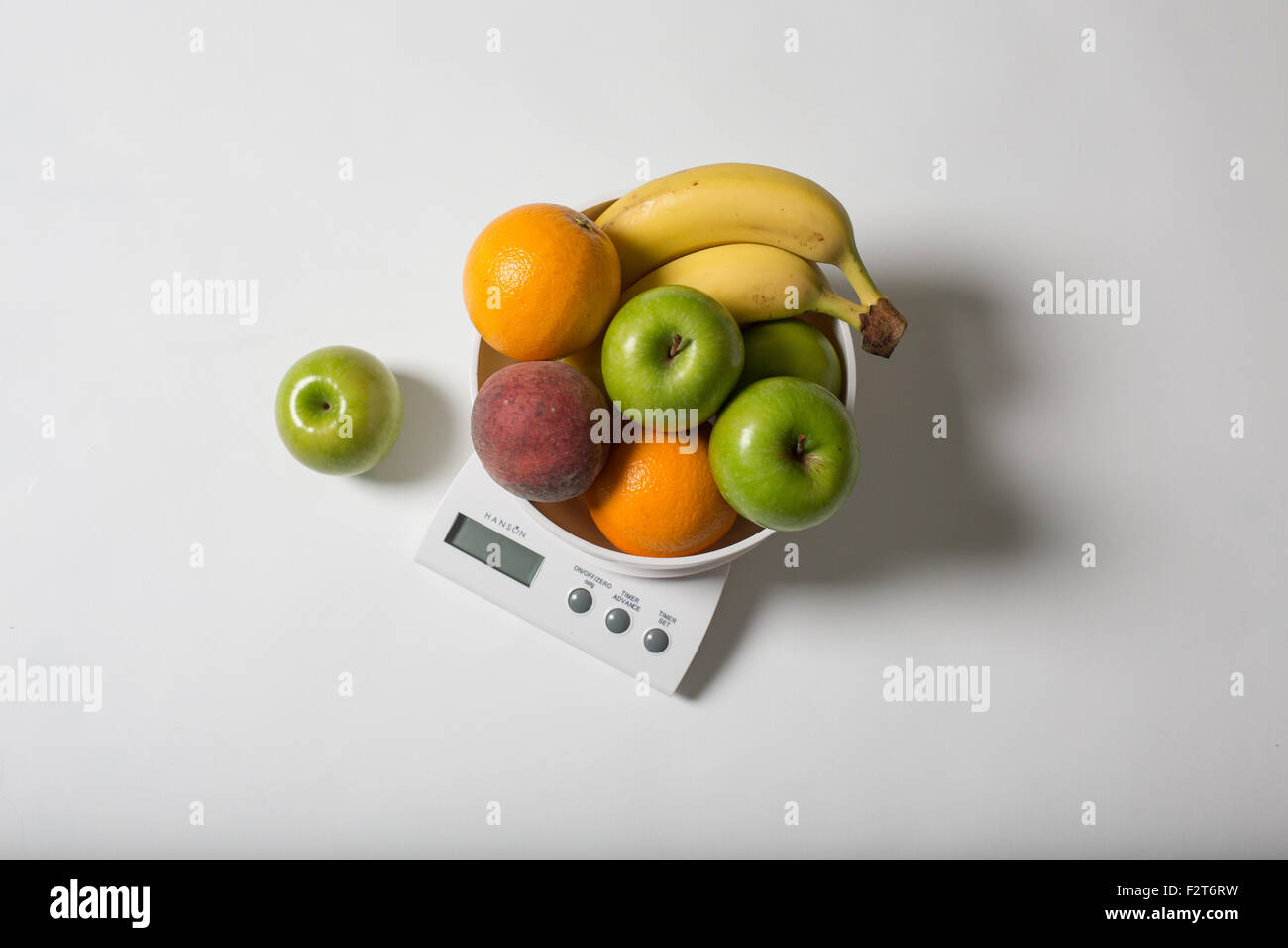fruit on weighing scales against a white background Stock Photo - Alamy