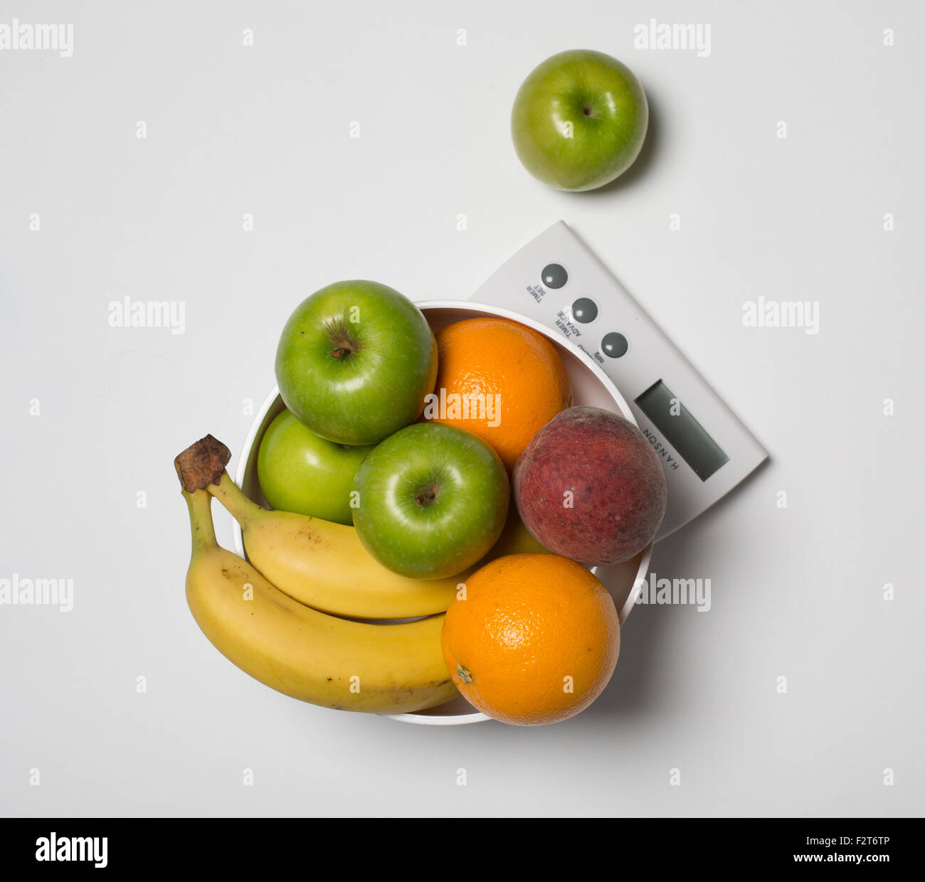 fruit on weighing scales against a white background Stock Photo - Alamy