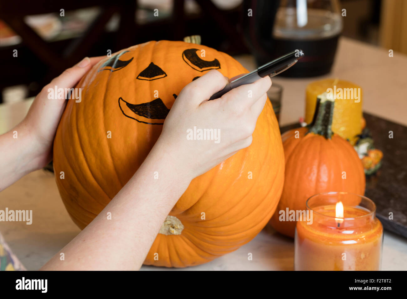 A young lady carving a pumpkin for the Halloween celebration Stock ...