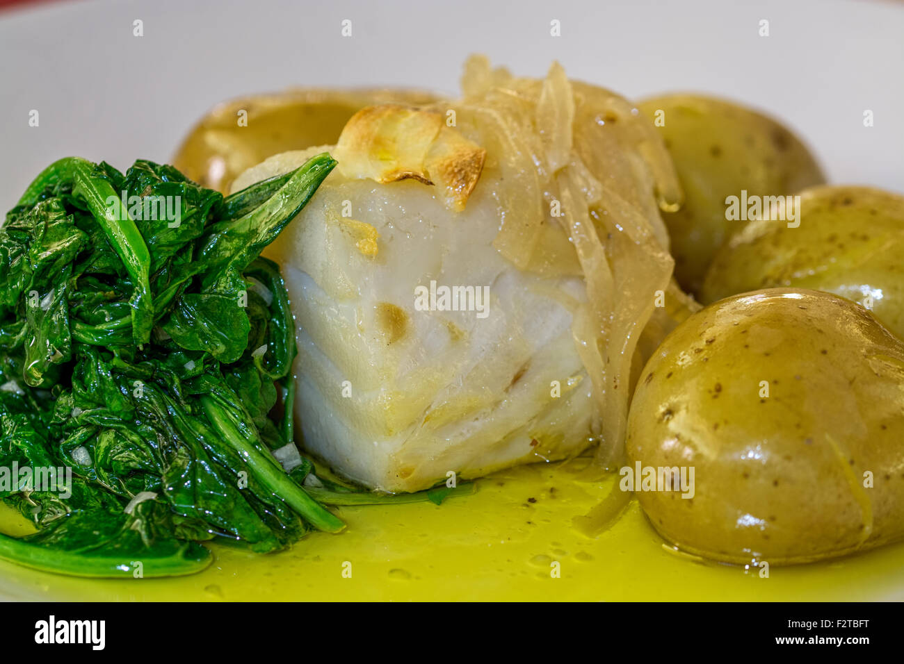 cod fish with potatoes and salted greens in olive oil Stock Photo - Alamy