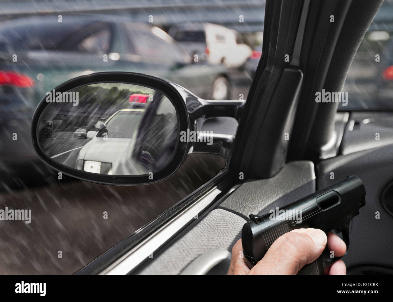man in car with gun police car in sideview mirror Stock Photo - Alamy