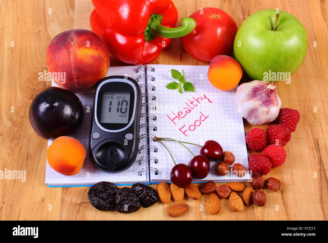 Fresh fruits, vegetables and glucose meter on notebook for writing ...