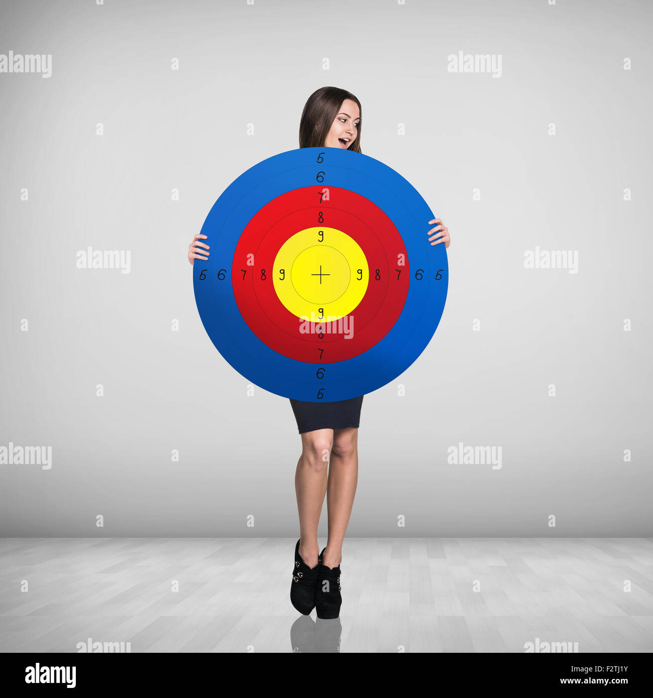 Surprised business woman holding big target Stock Photo - Alamy